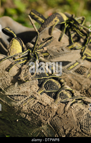 wet muddy running shoes coated in mud from cross country training ...