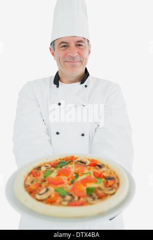 Happy chef offering pizza Stock Photo - Alamy