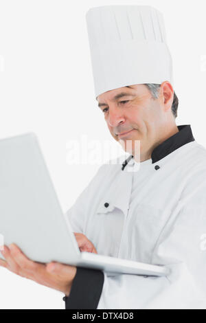 Closeup of male chef using laptop against white background Stock Photo ...