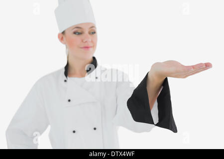 Chef in uniform looking at invisible product Stock Photo - Alamy