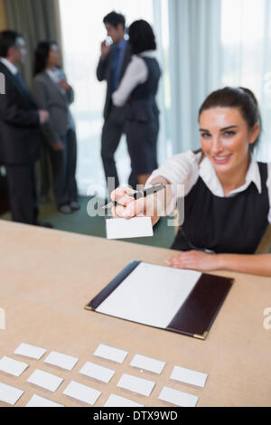 A woman writing her name on a name tag Stock Photo - Alamy