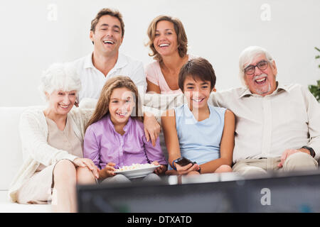 Extended family watching TV together Stock Photo - Alamy