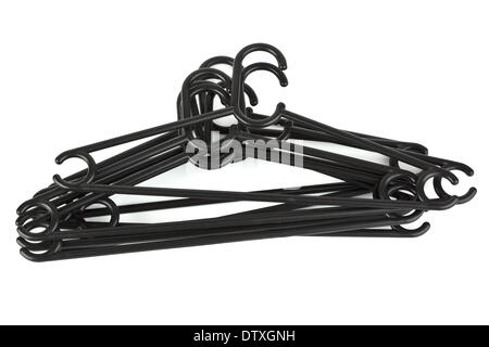 Stack of white wire clothes hangers laying on wood grain background ...