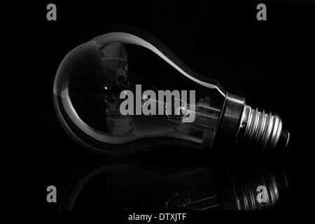 Clear light bulb laying on its side on reflective surface Stock Photo ...