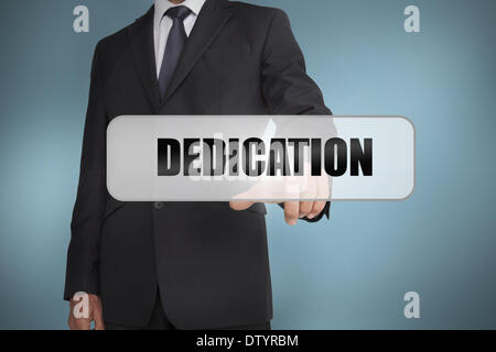 Businessman selecting the word dedication written on white tag on blue ...