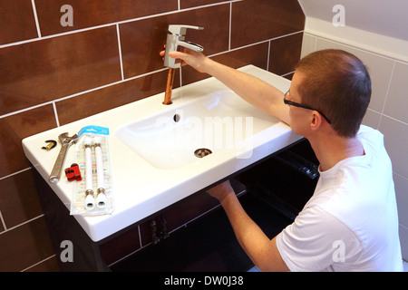DIY plumber fitting a tap during a new bathroom renovation Stock Photo ...