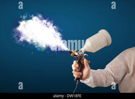 Painter with airbrush gun and white magical smoke Stock Photo - Alamy