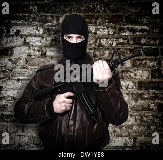 Portrait of a dangerous armed terrorist with mask and gun in a ...