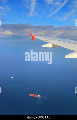 Transportation, cargo ships under wing of flying plane Stock Photo - Alamy