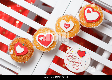 valentine's day muffins with red and white hearts on a white wooden ...