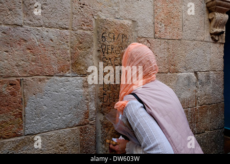Eastern Orthodox Pilgrim kissing a religious icon as she prays inside ...