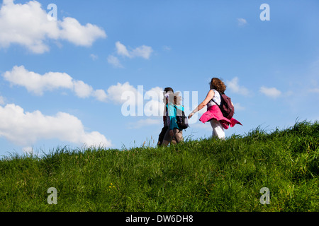 tourists walking on the dike, background blue sky with white clouds ...