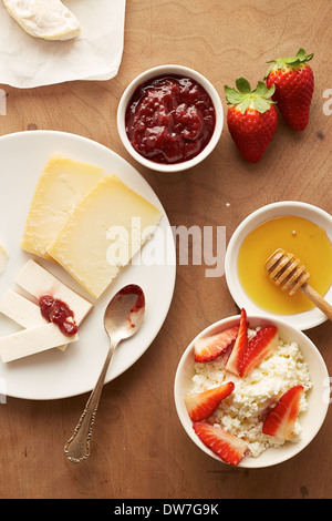 Plate with different types of cheese and cup of honey Stock Photo - Alamy