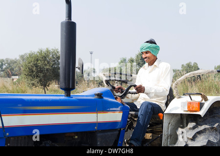Indian farmer driving tractor Stock Photo - Alamy