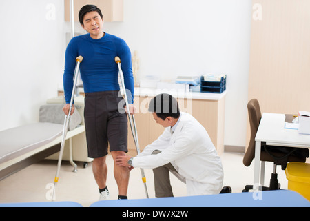 Doctor examining patient with broken leg Stock Photo - Alamy