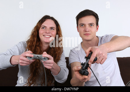 Happy young couple playing video games with virtual reality headsets ...