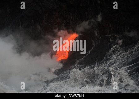 Waves crashing and lava from Kilauea Volcano flowing into the ocean ...