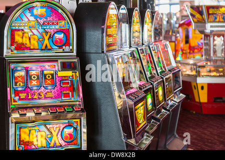 Brightly coloured slot, gaming and fruit machines in amusement arcade ...