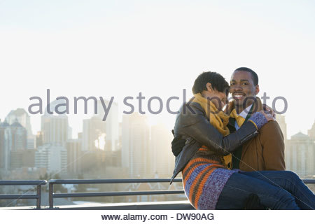 Man picking up woman on snowy pier Stock Photo - Alamy