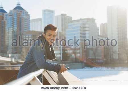 Man leaning against railing, looking into distance, low angle view ...