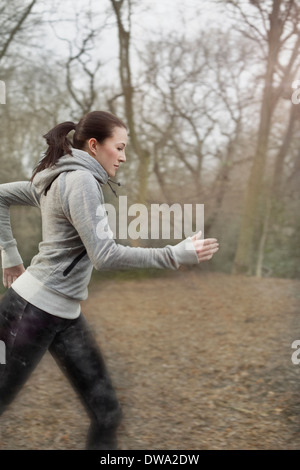 Young woman running through forest Stock Photo - Alamy