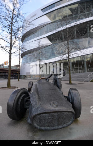 Bronze statue of Juan Manuel Fangio standing alongside his grand prix ...