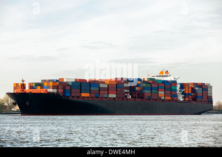 A cargo vessel fully laden with containers passing under the Ponte 25 ...