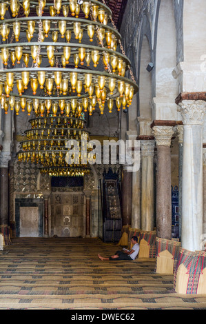 A vertical shot of an arch building with a man passing by during a ...