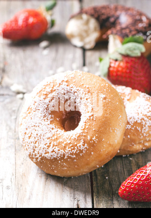 A glazed round pastry with red crumb topping and white drizzle sits on ...