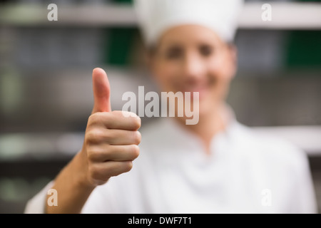 Happy chef smiling at camera giving thumbs up in a commercial kitchen ...
