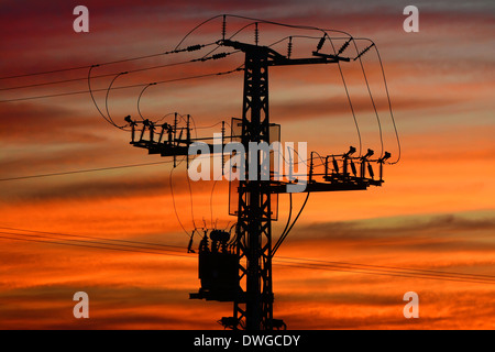 Silhouette of electricity pylon at sunset Stock Photo - Alamy