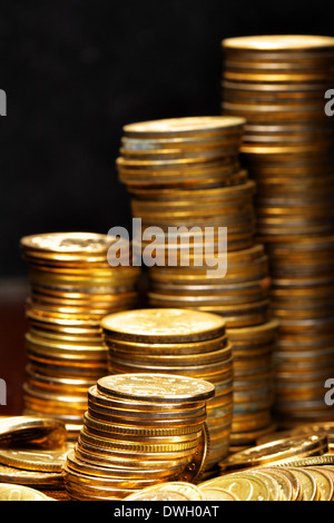 Stacks of golden coins on a black pedestal. Wealth concept. Pure white ...