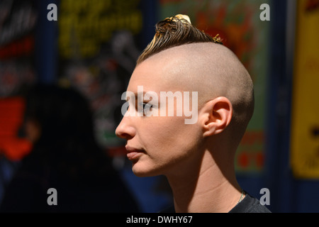 Portrait of a woman with a partially shaved head and tattoos of Middle ...