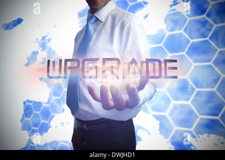 Businessman presenting the word upgrade Stock Photo - Alamy