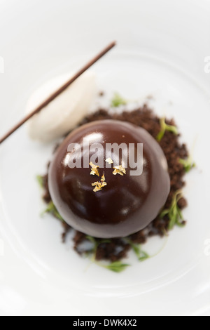 Chocolate bombe dessert served with vanilla ice cream Stock Photo - Alamy