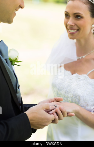 Young bridegroom putting on the wedding ring on his wife's finger Stock ...