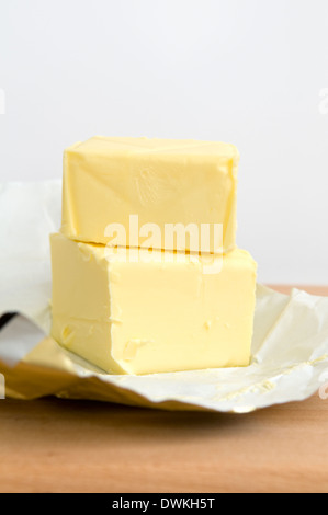 Open pack of butter on wooden chopping board Stock Photo - Alamy