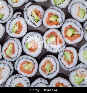 Sushi rolls with nori, rice, pieces of avocado, cucumber, flying fish ...