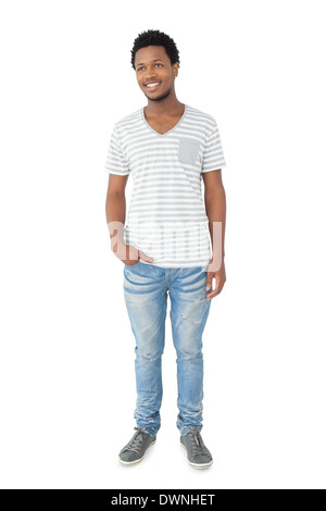 Portrait of smiling young man with full shopping cart in fruit market ...