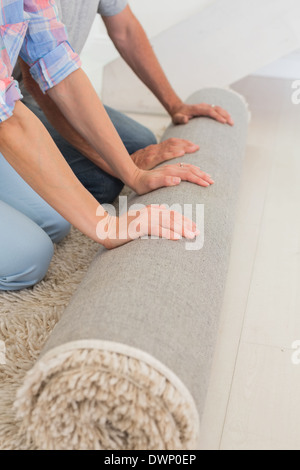 A couple rolling out a rug Stock Photo - Alamy