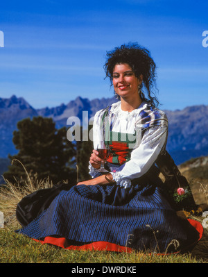 Young woman in Tyrolean costume in front of mountain backdrop, Pitztal ...