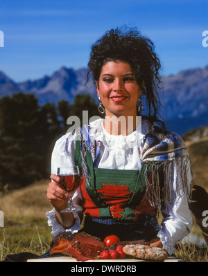 Young woman in Tyrolean costume contemplates from the balcony of ...