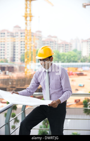 indian male architect reading plans with construction background Stock ...