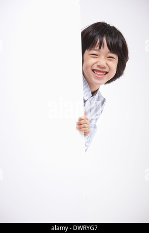 Boy hiding behind a white wall Stock Photo - Alamy