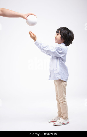 a kid receiving a ball in white background Stock Photo - Alamy