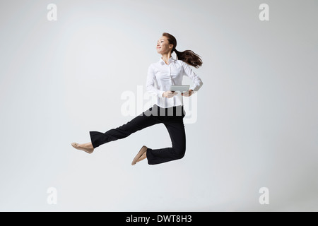 a woman making dance poses with a tablet Stock Photo - Alamy