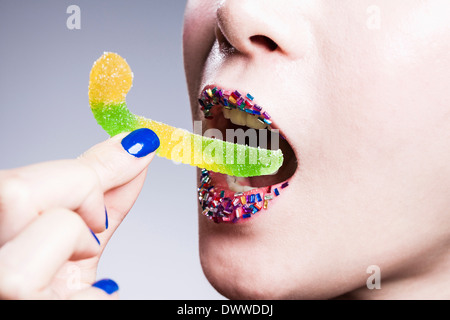 a woman with colorful lips eating candy Stock Photo - Alamy