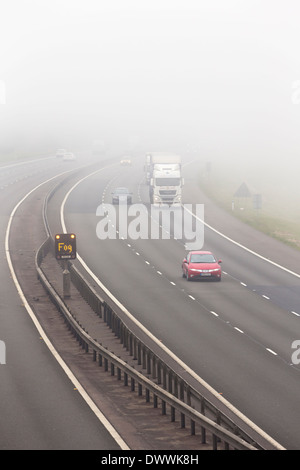 UK motorway with fog warning sign in fog or foggy conditions Stock ...