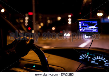 Driving a car at night -man driving his modern car at night in a city ...