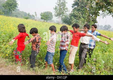 Line of happy young rural Indian village girls sitting on a wall ...